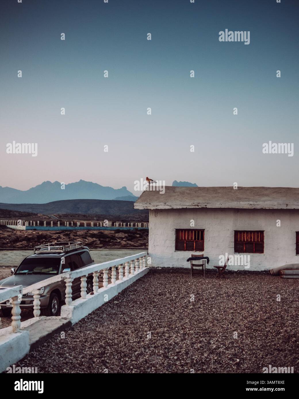 Coastal building at sunset with mountain backdrop on Delisha Beach ...