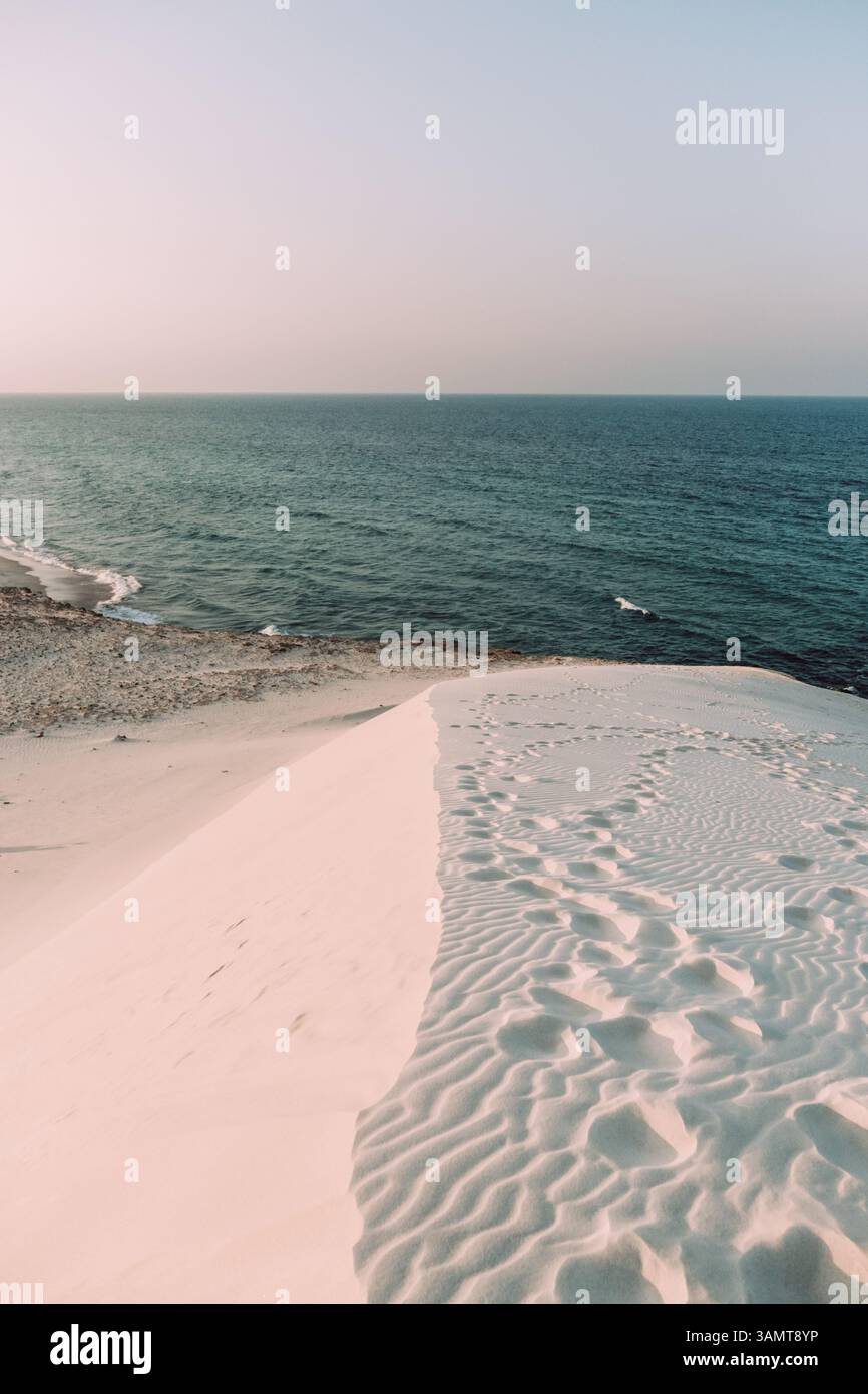Footprints trail across wind-sculpted sand dunes on Delisha Beach ...