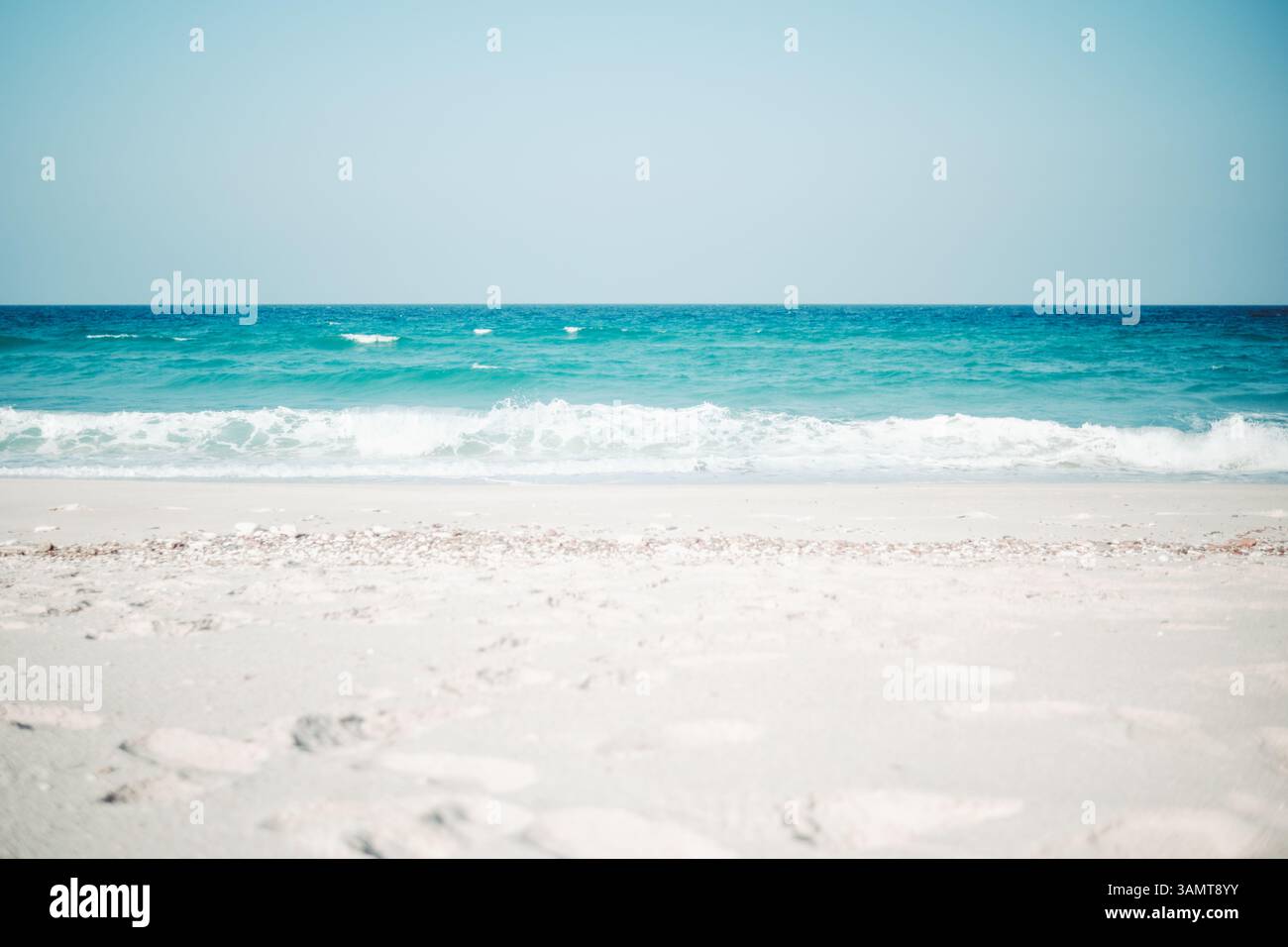 Pristine sandy beach with turquoise waters and mountain backdrop at ...