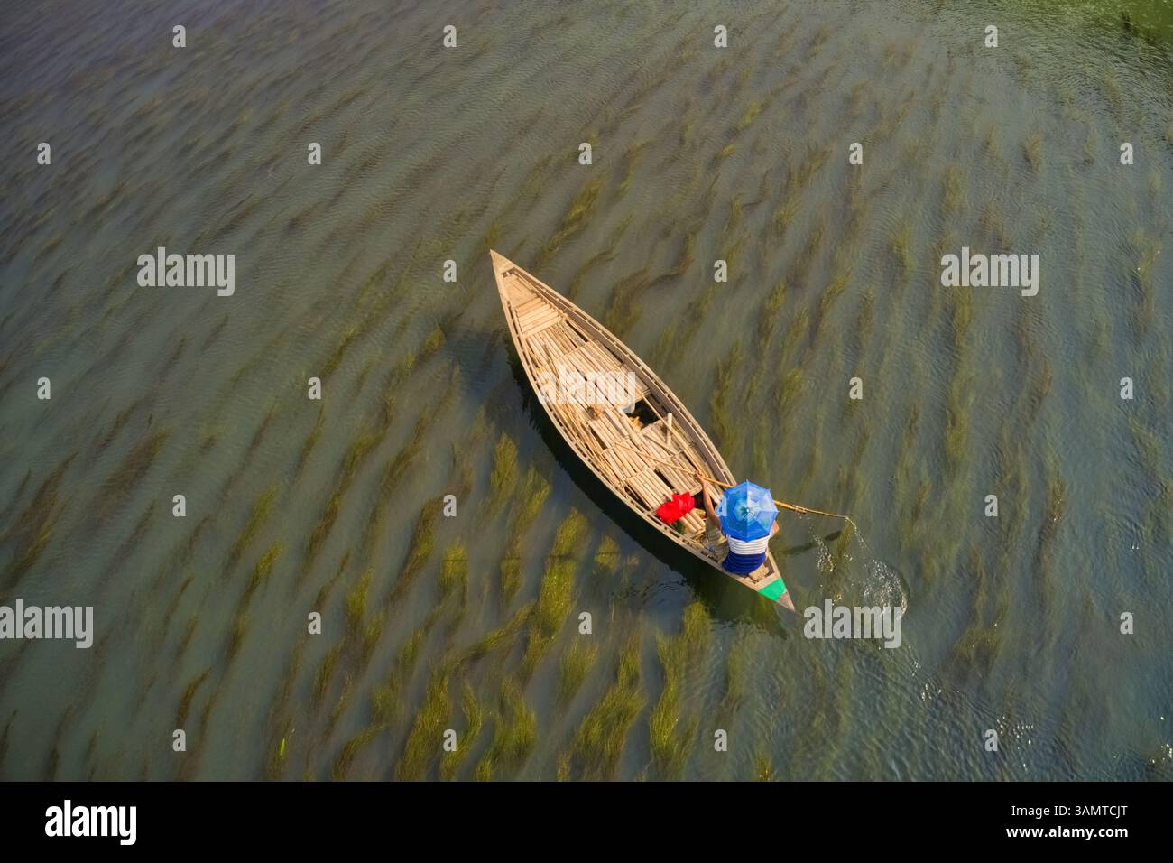 Aerial view of a fisherman wearing a traditional hat and sailing the ...