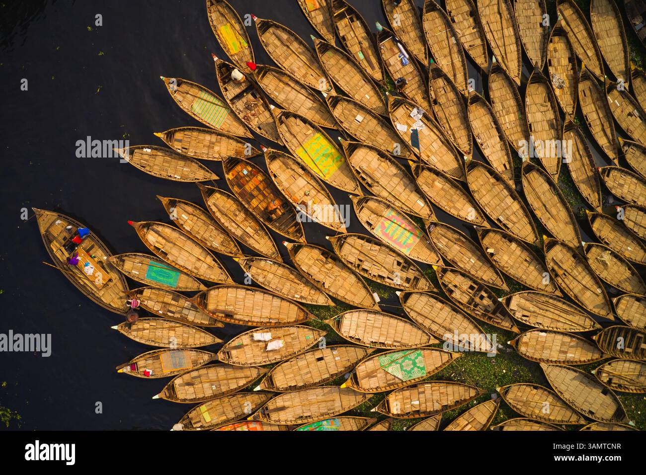 Aerial view of traditional fishing boats among docked ferry boat along Buriganga river in ...