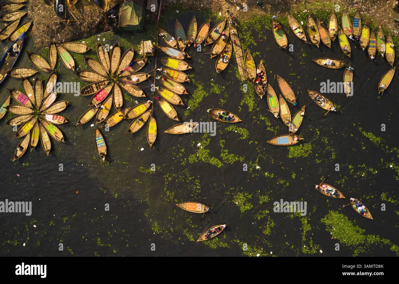 Aerial view of traditional fishing boats among docked ferry boat along Buriganga river in ...