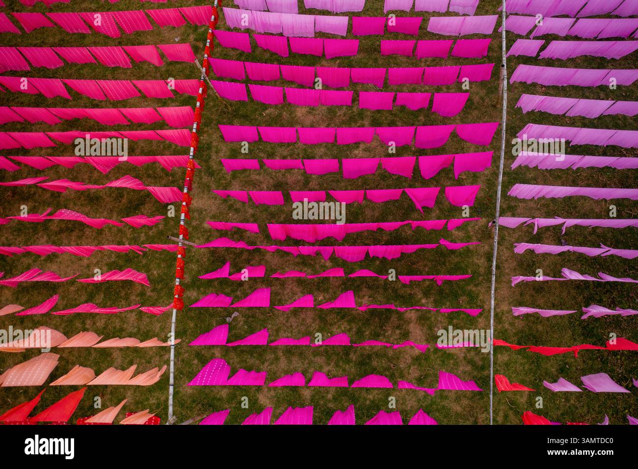 Aerial view of a man hanging colourful cloth in a public laundry in ...