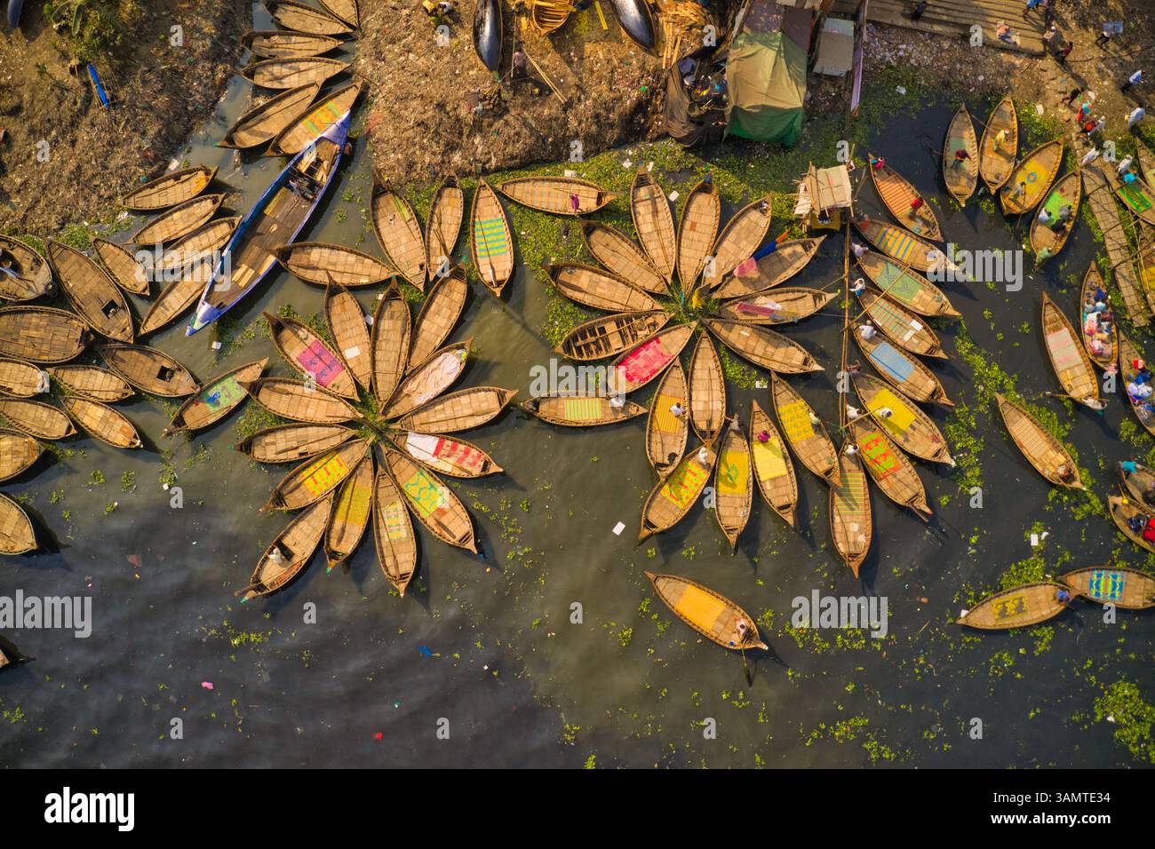Aerial view of traditional fishing boats among docked ferry boat along Buriganga river in ...