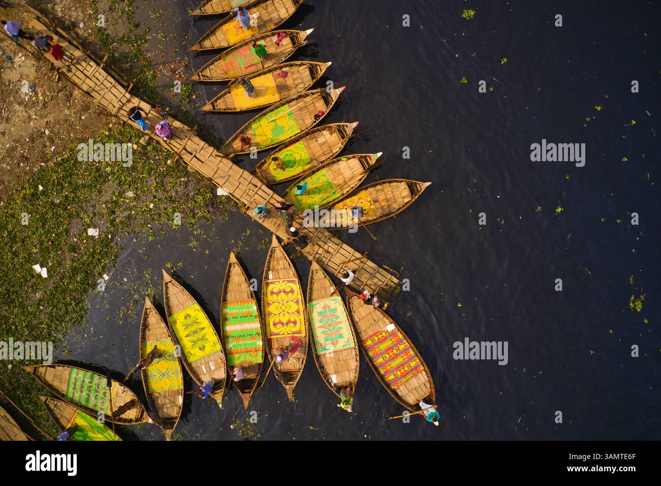 Aerial view of traditional fishing boats among docked ferry boat along Buriganga river in ...
