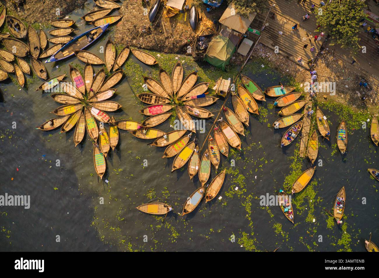 Aerial view of traditional fishing boats among docked ferry boat along Buriganga river in ...