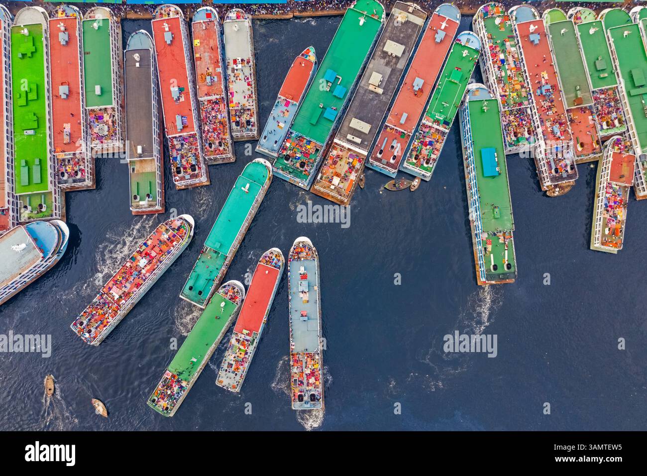 Aerial view of a few ferry boats randomly docked along Buriganga river side in Dhaka city centre ...