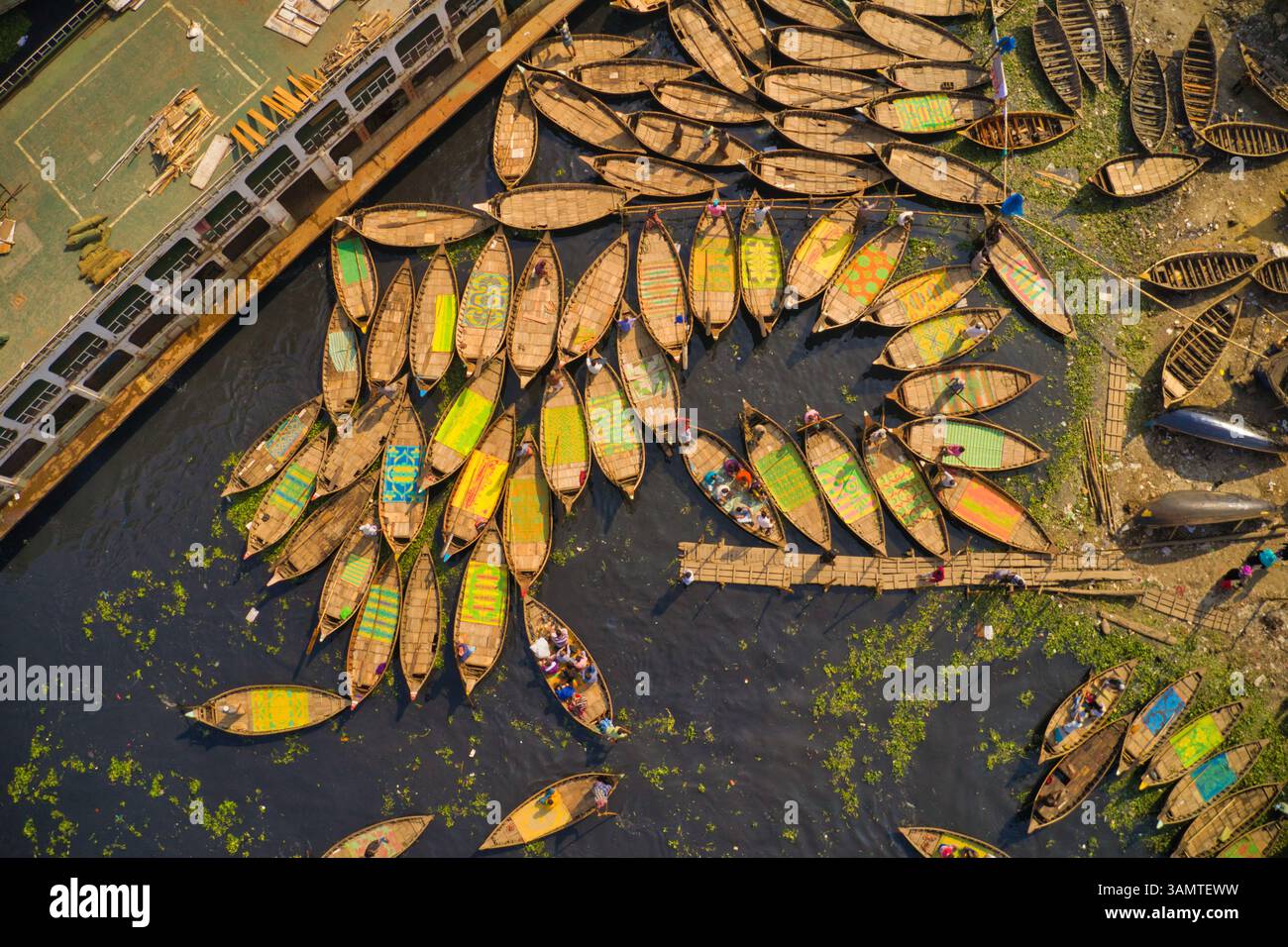 Aerial view of traditional fishing boats among docked ferry boat along Buriganga river in ...