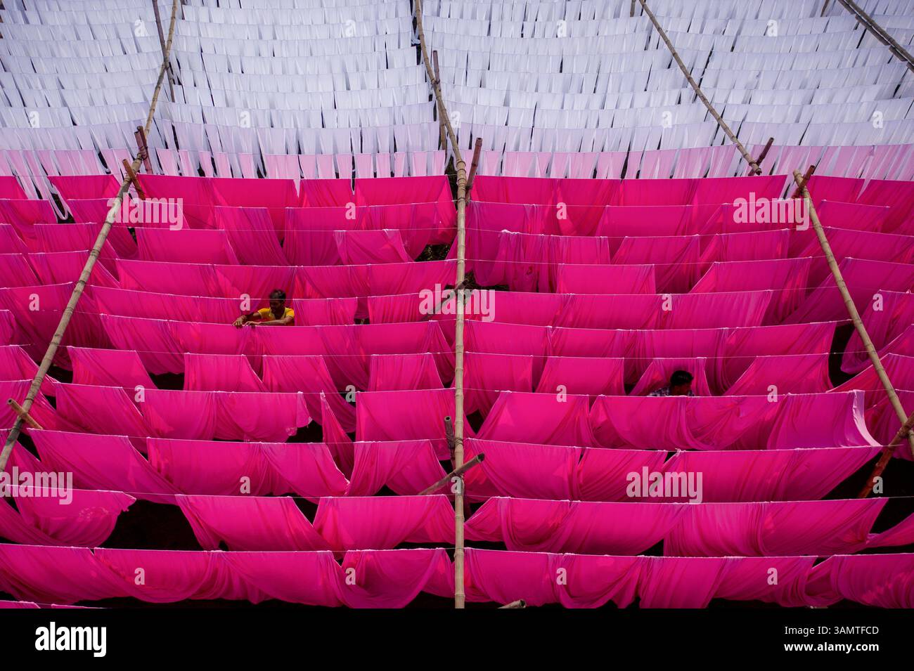 Aerial view of a man hanging colourful cloth in a public laundry in ...