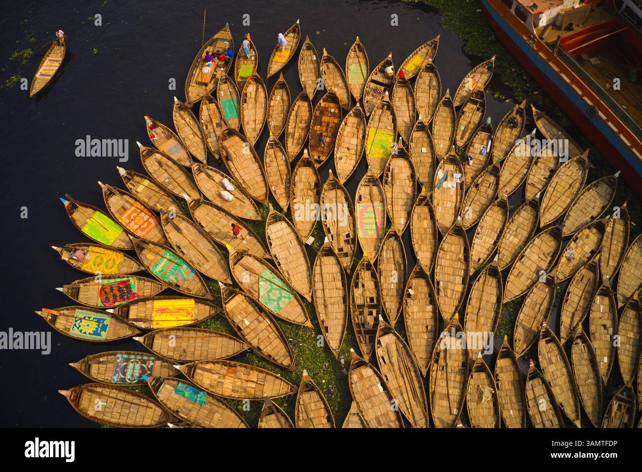 Aerial view of traditional fishing boats among docked ferry boat along Buriganga river in ...