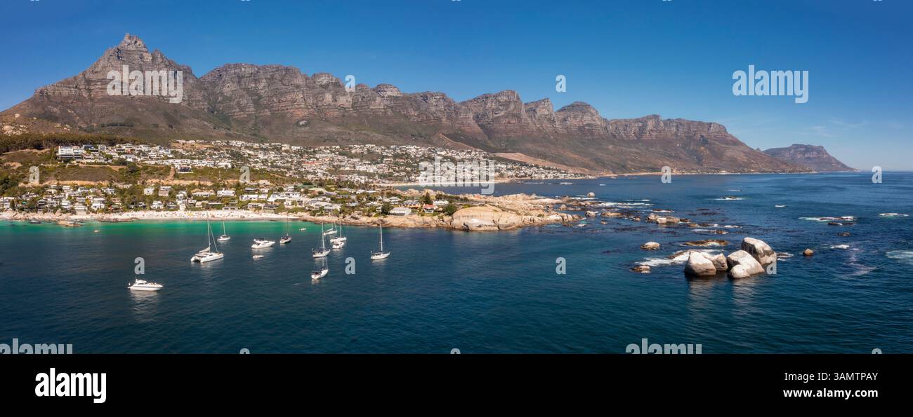 Aerial view of Camps Bay with boats, ocean, beach, and Twelve Apostles ...