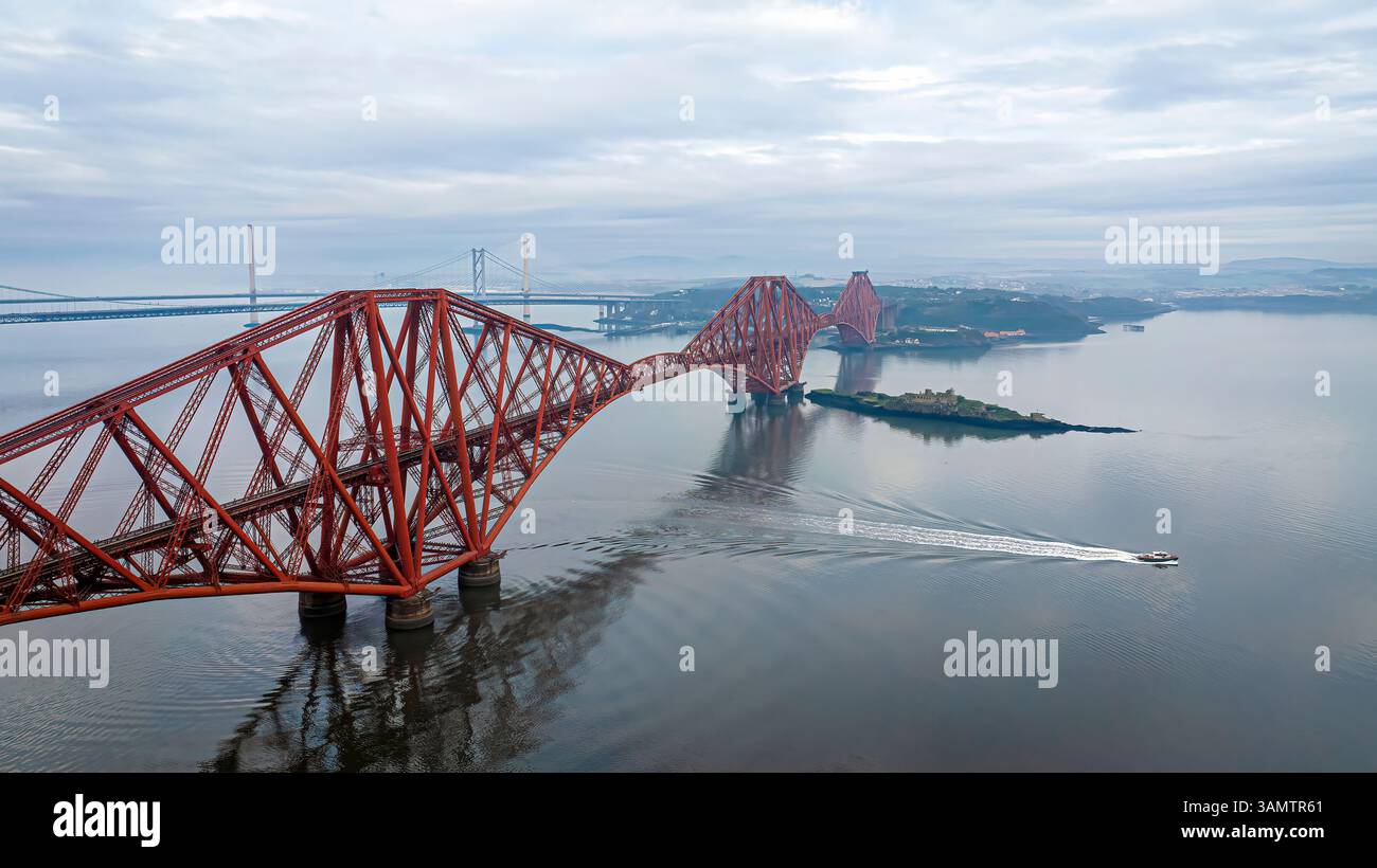 Aerial view of the iconic Forth Rail Bridge over the water with boats ...