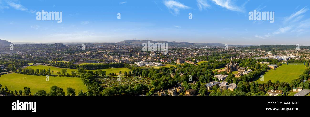 Aerial view of urban park with fields, trees, buildings, and mountains ...