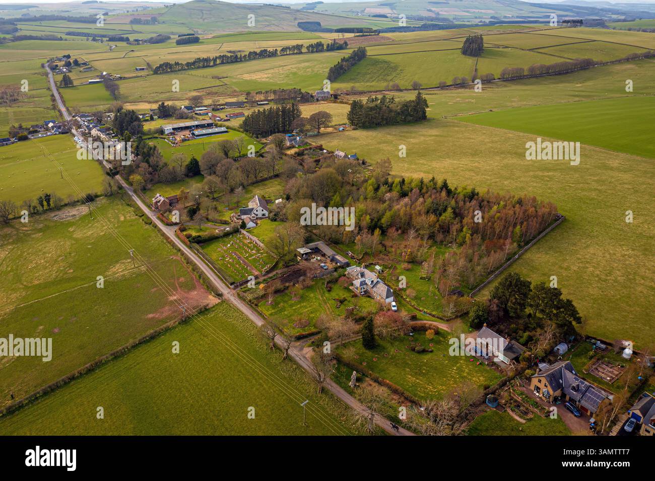 Aerial view of peaceful village life surrounded by fields, trees, and ...