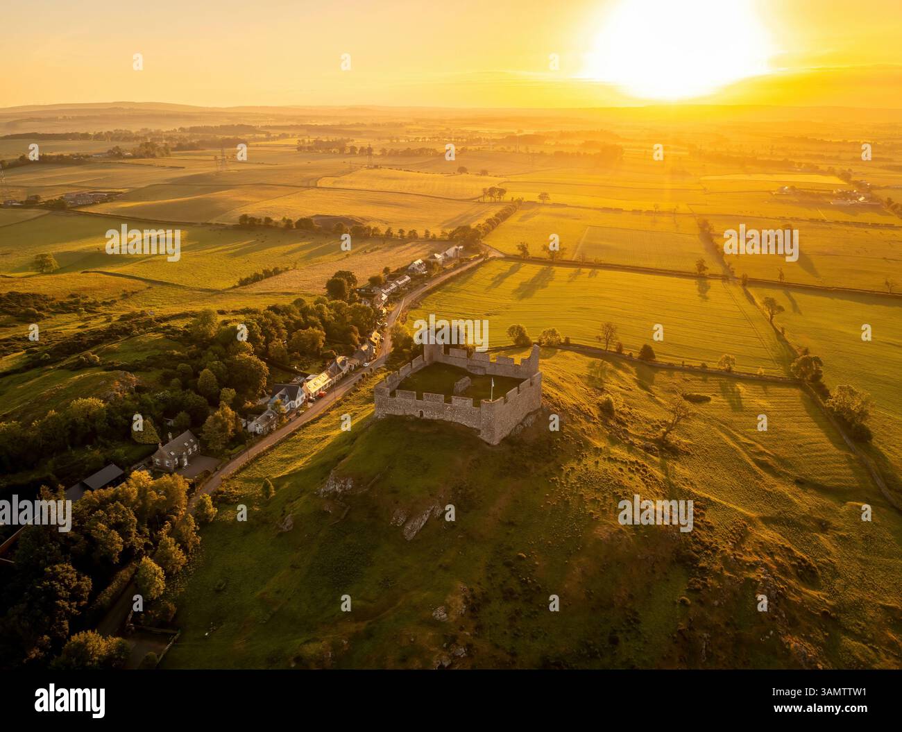 Aerial view of Hume Castle at sunset surrounded by countryside fields ...