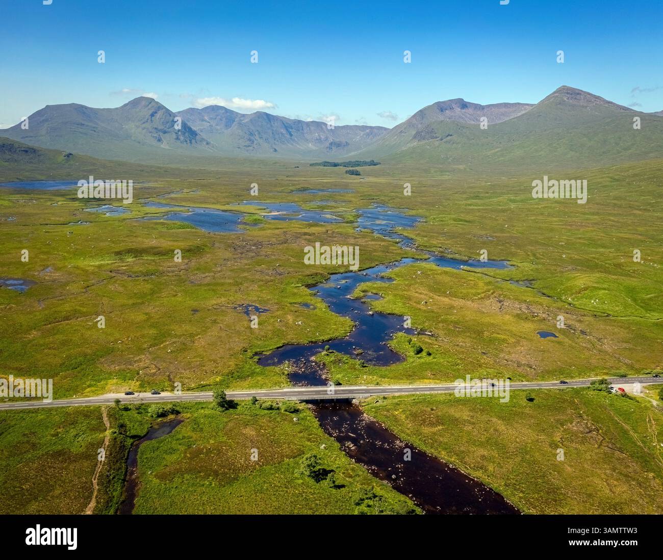 Aerial view of remote valley with bridge and winding road, Rannoch Moor ...