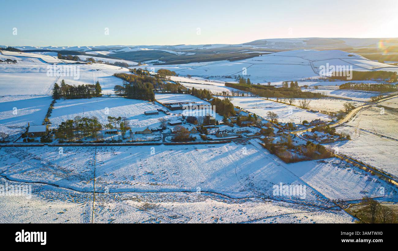Aerial view of snowy village surrounded by fields and forests, Chesters ...