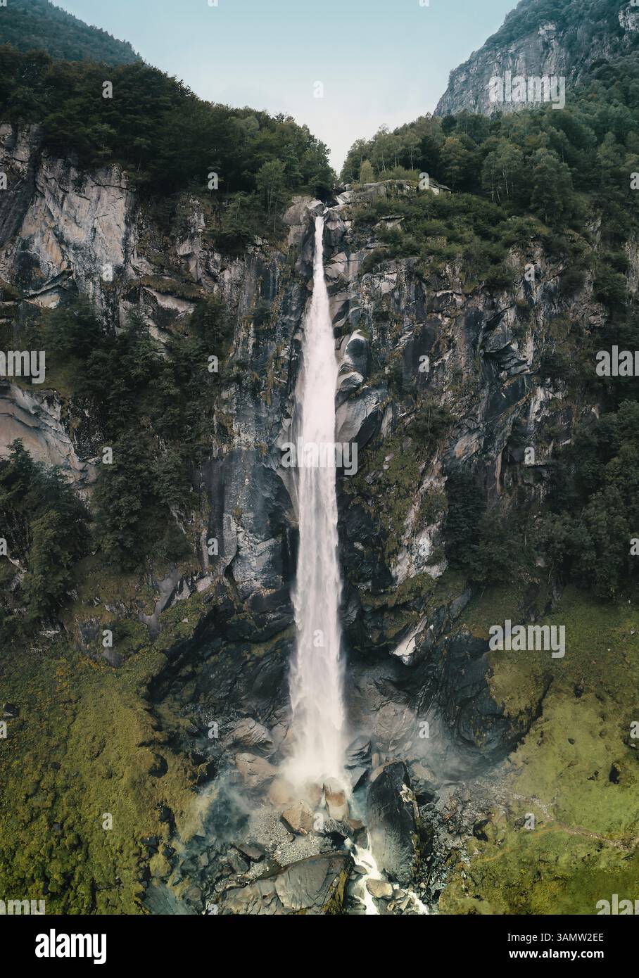 Aerial view of a majestic steep waterfall surrounded by lush forest in ...