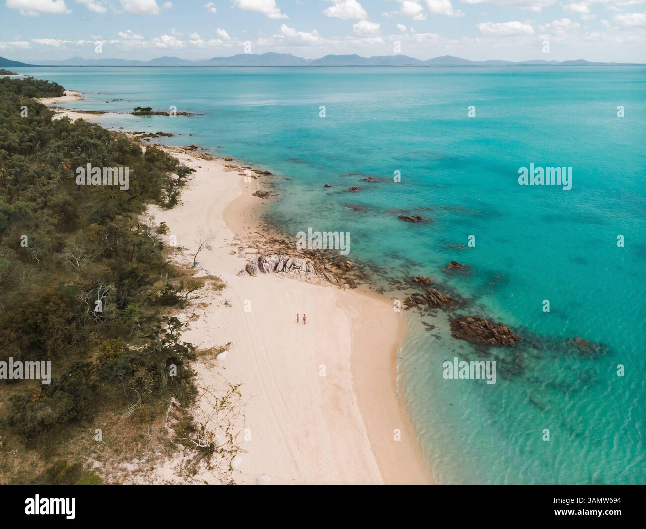 Aerial view of a couple on the beach at Hideaway Bay, Queensland ...