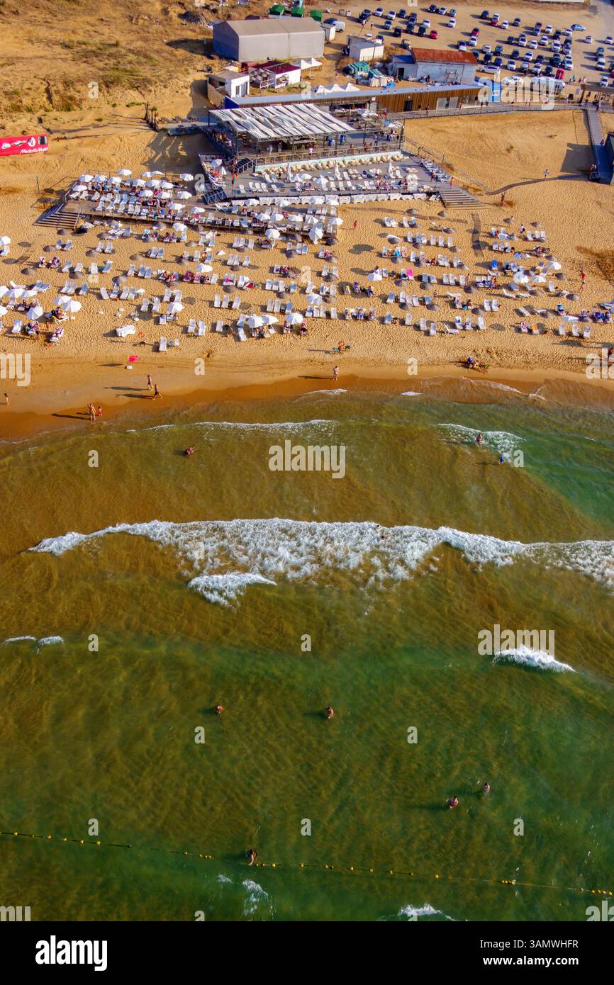 Aerial view of a beautiful sandy beach with people enjoying the sunny ...
