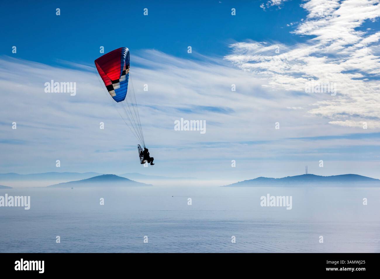 Aerial view of paramotor flying near Princes' Islands over foggy Marmara Sea in Asian side of ...