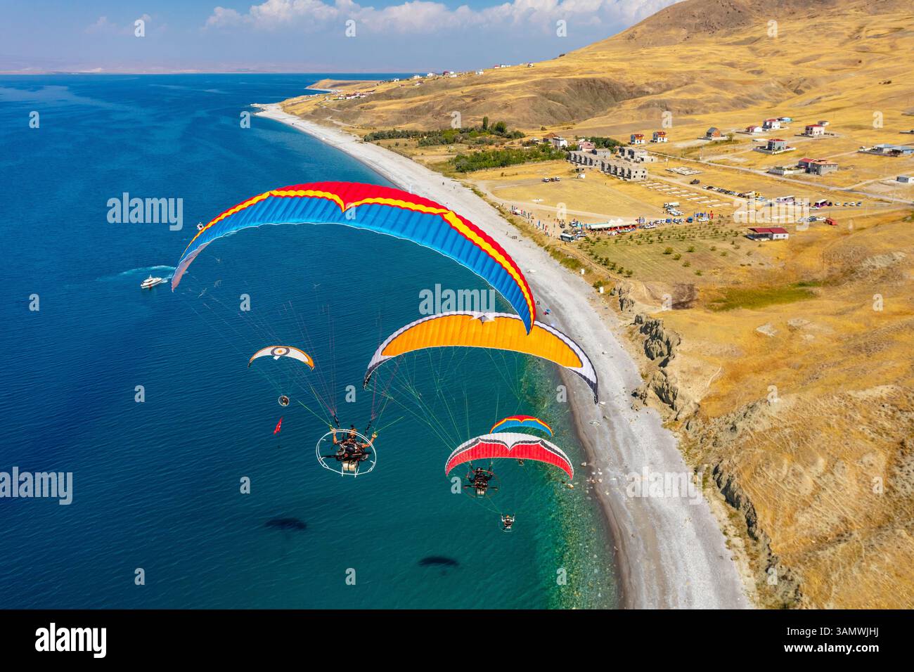Aerial view of paramotors flying in formation at Van Lake coastline ...