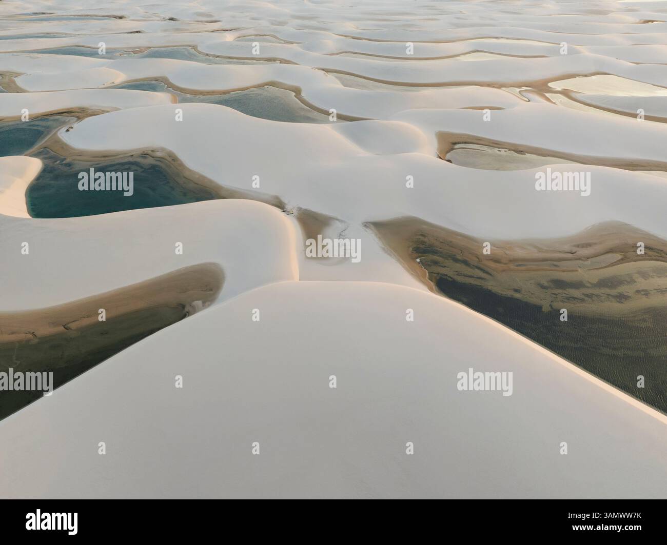 Aerial view of desert lagoon with turquoise water and sand dunes ...