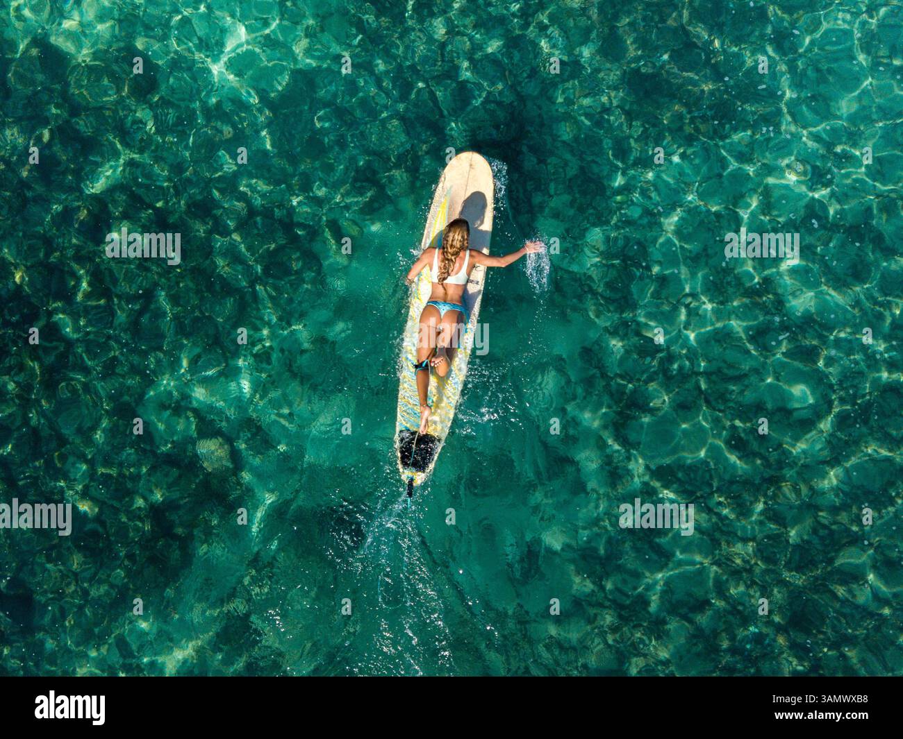 Aerial view of Trois Bassin Surf Spot, surfer paddling vertical view ...