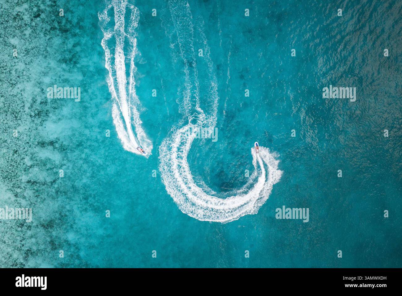 Aerial Top Down View Of People Circling Around On Jet skis Over Blue ...