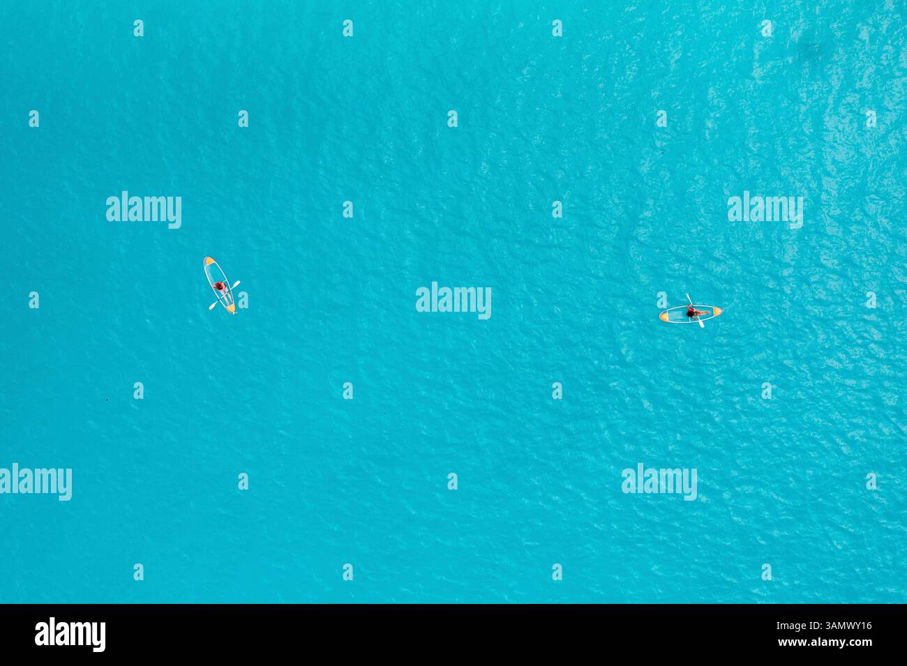 Aerial Top Down View Of Two People Kayaking Over Clear Blue Ocean Water ...