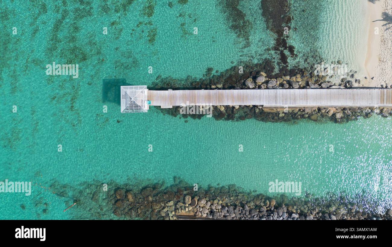 Aerial view of Sandyport beach with turquoise water and wooden shore ...