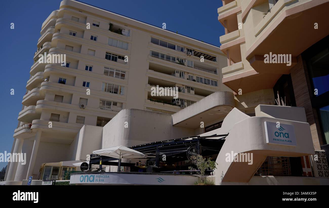 White apartment building with balconies overlooking restaurant below ...
