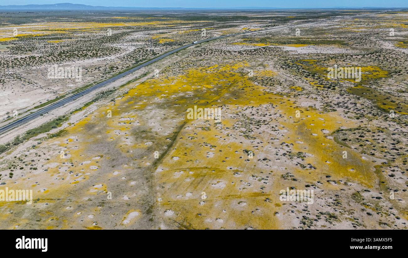 Aerial view of a scenic desert landscape with a road and truck amidst ...