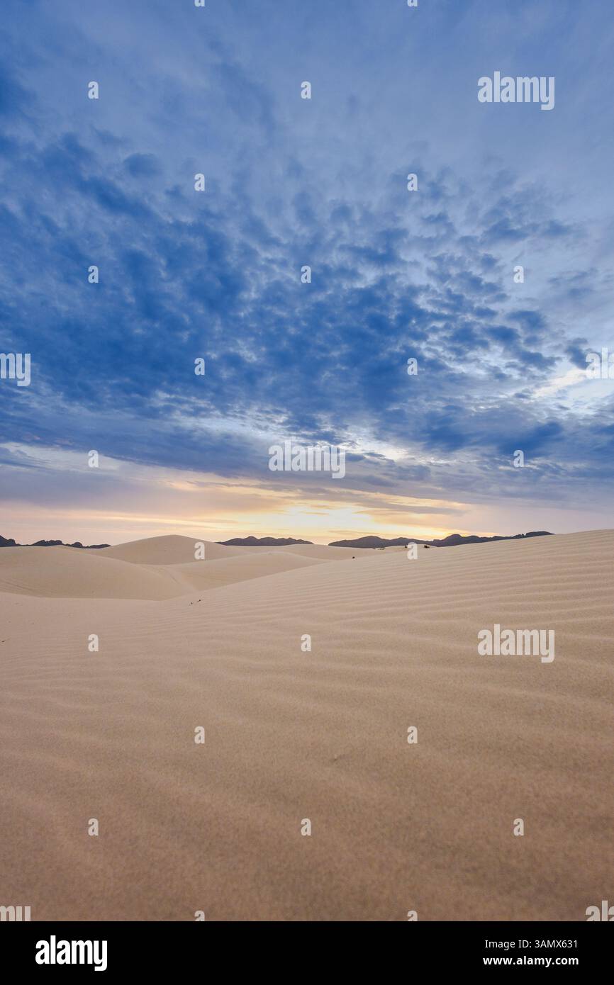 Aerial view of beautiful sand dunes under a serene sunset sky with ...