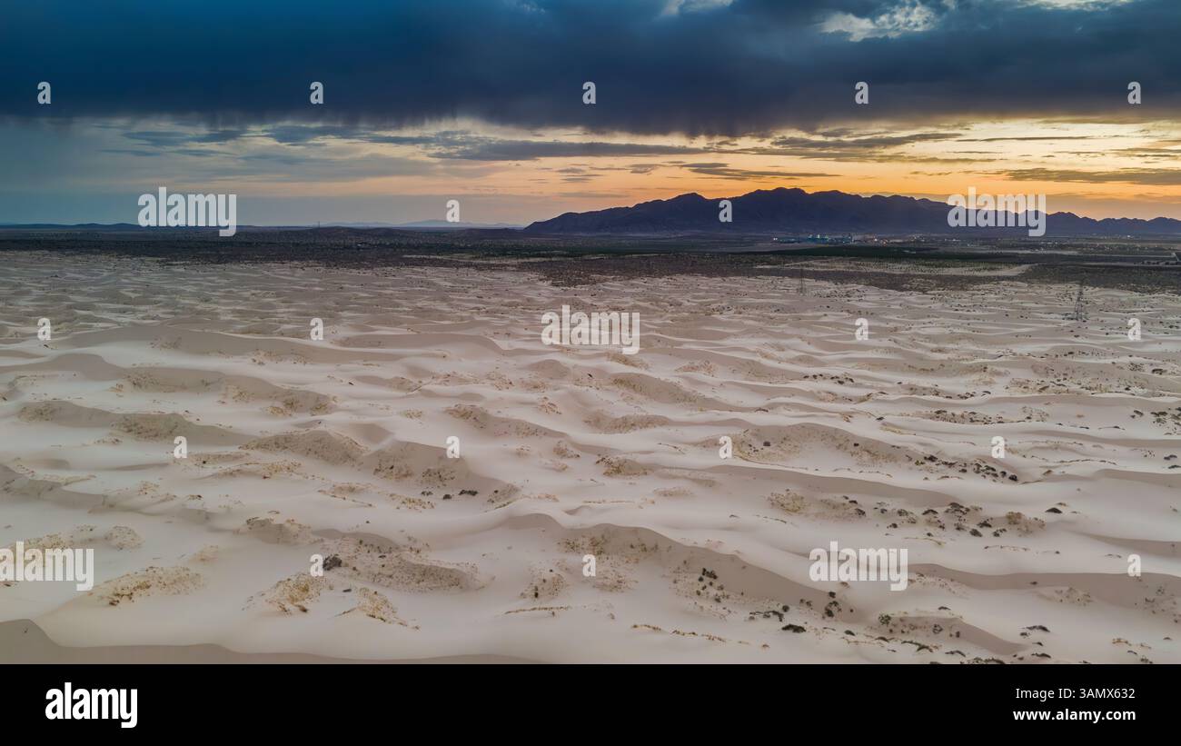 Aerial view of breathtaking sand dunes under a serene sunset sky with ...
