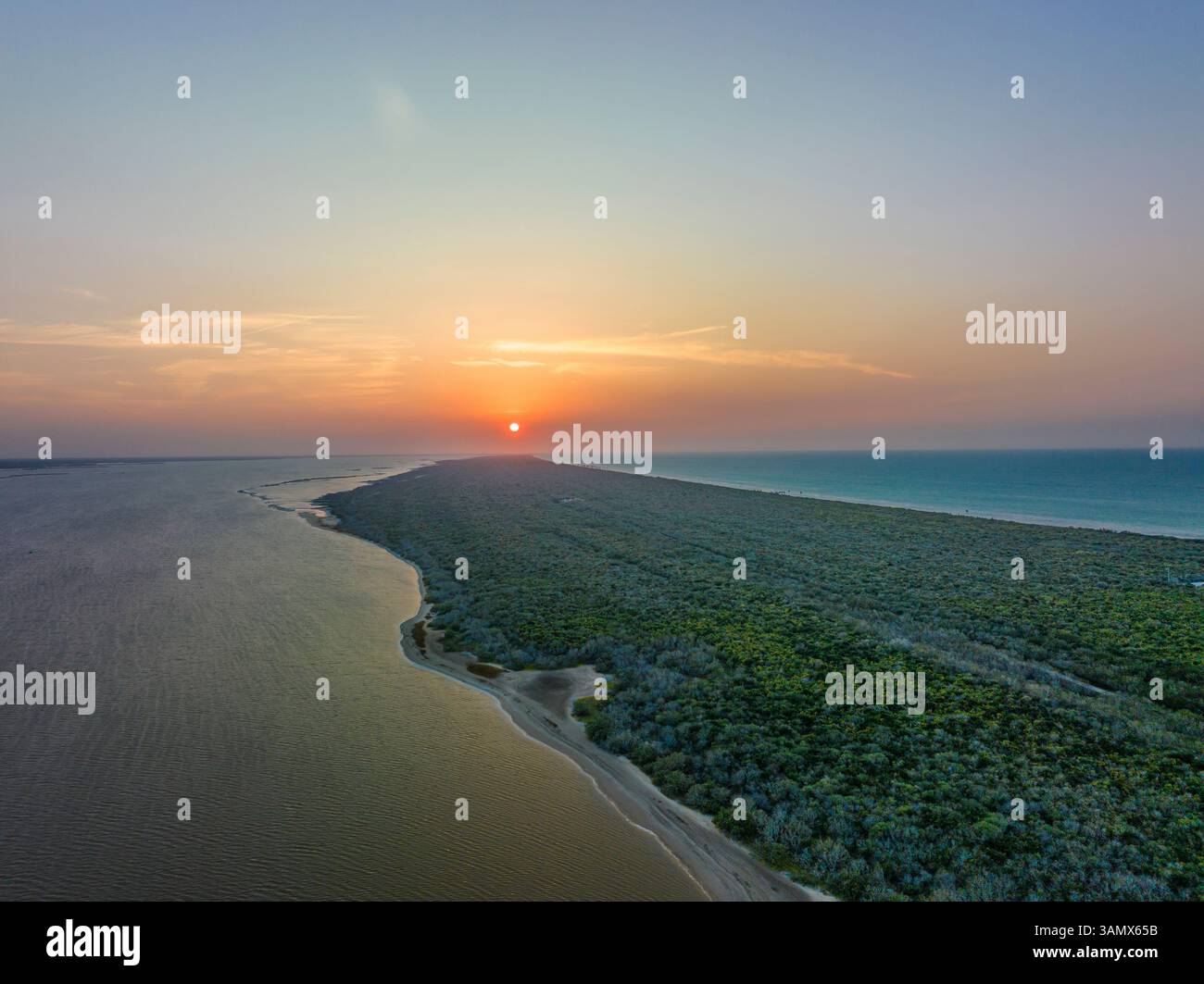 Aerial view of beautiful sunset over El Cuyo Estuary with serene coast ...