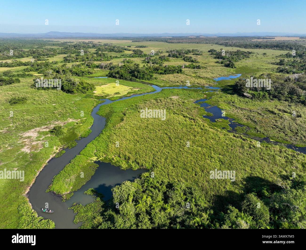 Aerial view of lush wetland and river surrounded by expansive grassland ...