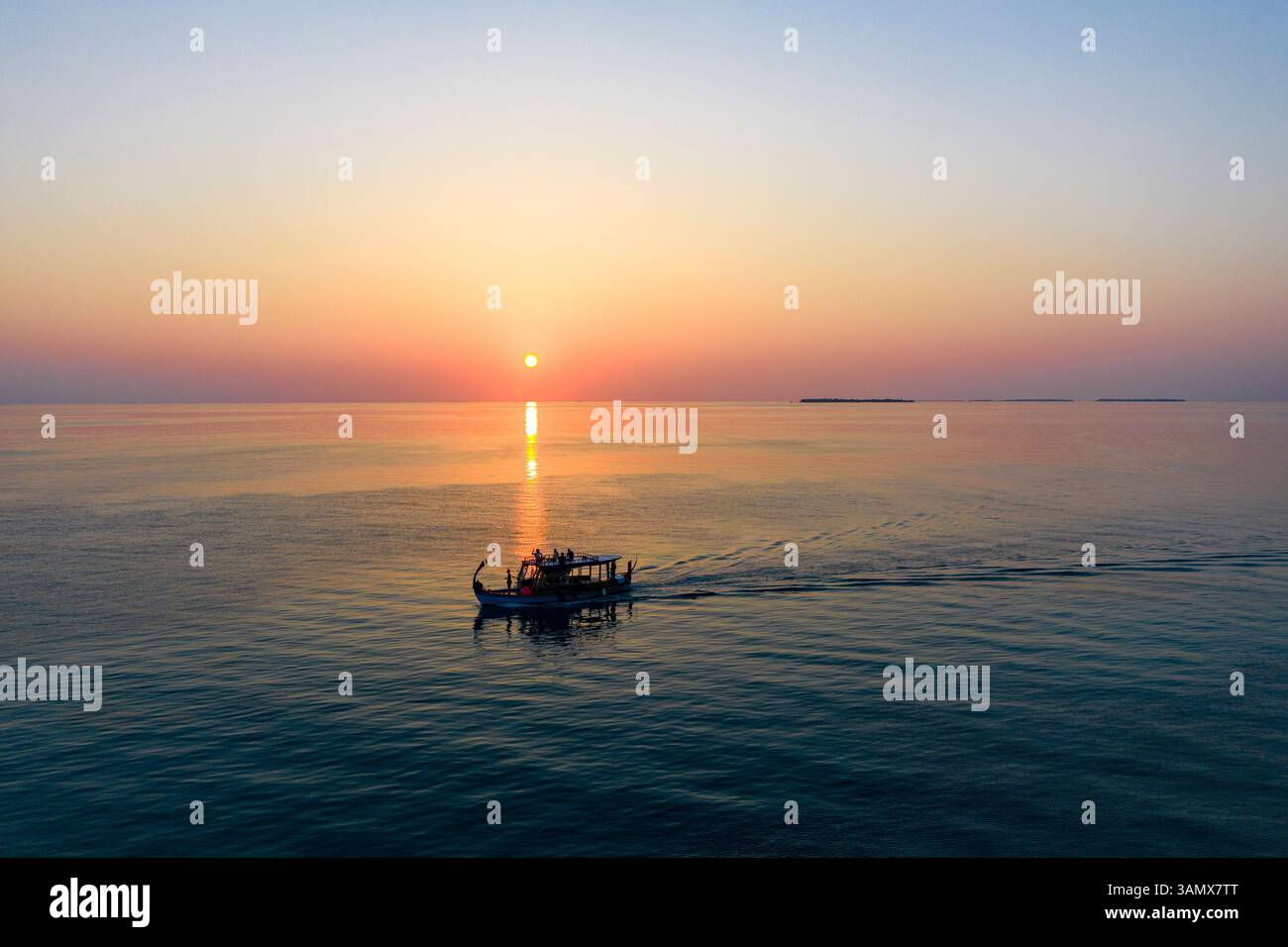 Aerial view of a tranquil sunset over the ocean with a silhouette of a ...