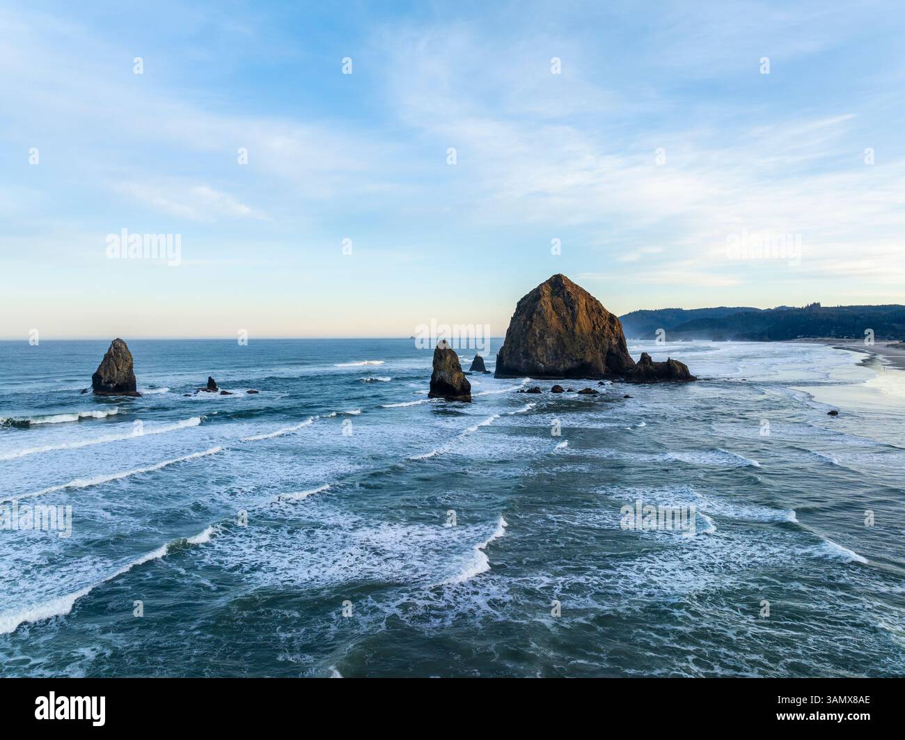 Aerial view of rugged coastline with Haystack Rock and waves crashing ...