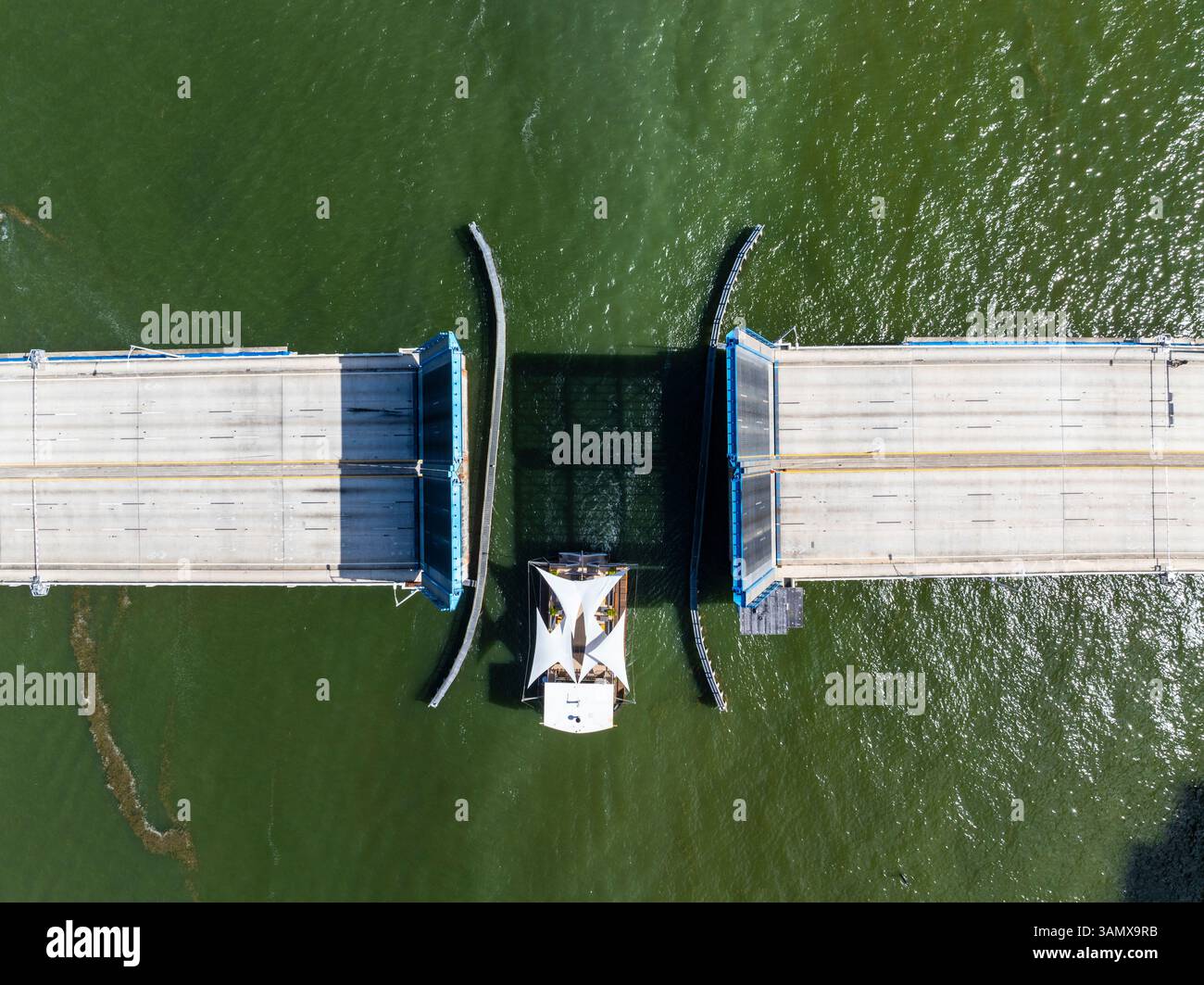 Aerial view of the open drawbridge over green water with boats ...
