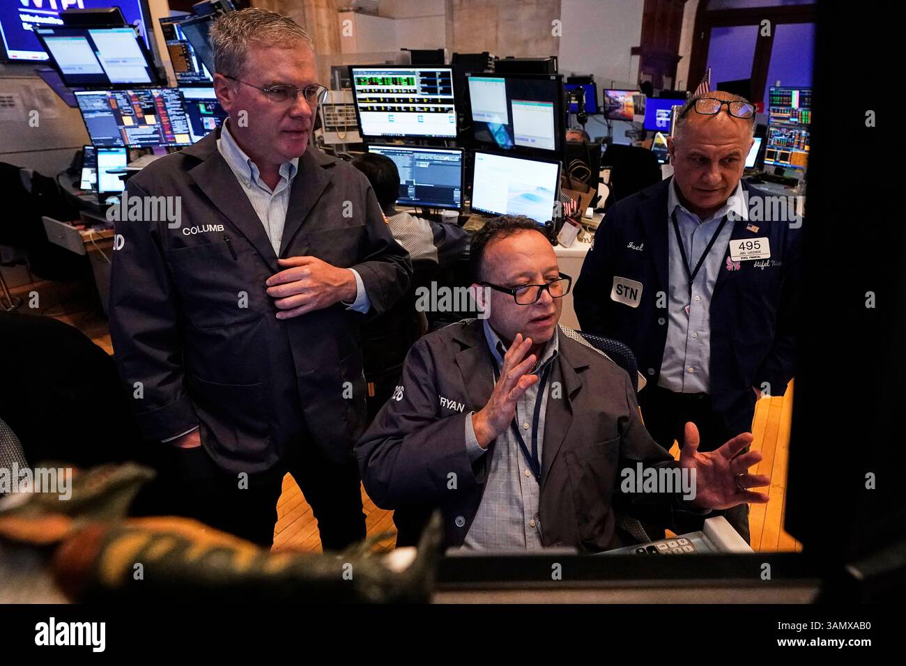A trio of traders work on the floor of the New York Stock Exchange ...