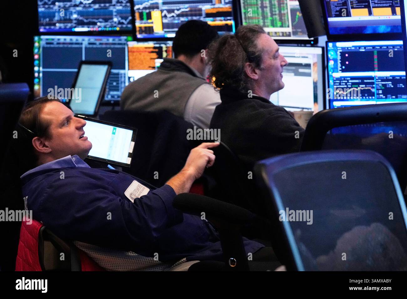Trader Michael Milano, left, works with colleagues on the floor of the ...
