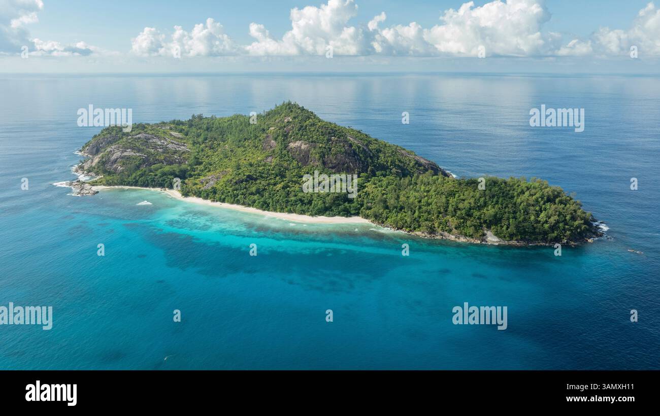 Aerial view of lush Therese Island surrounded by tranquil blue ocean ...