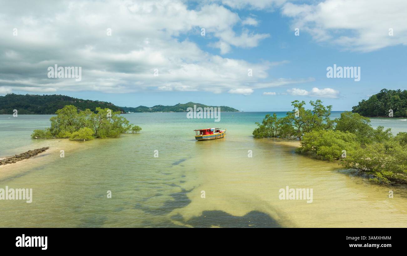 Aerial view of tropical island with fishing boat, mangroves, and clear ...