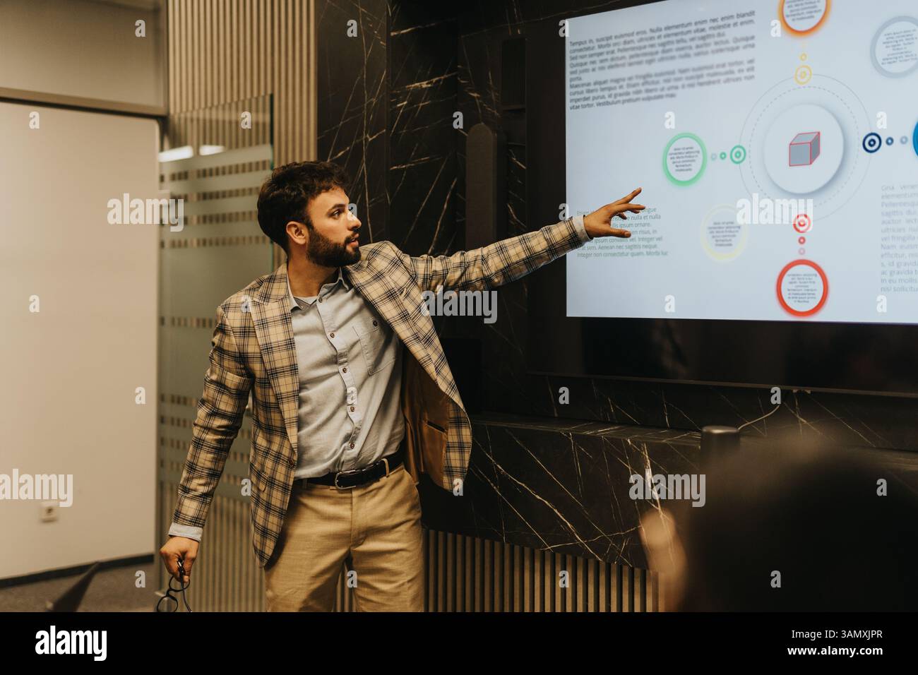 A business person presents late at night with a digital screen, using visuals to explain data ...