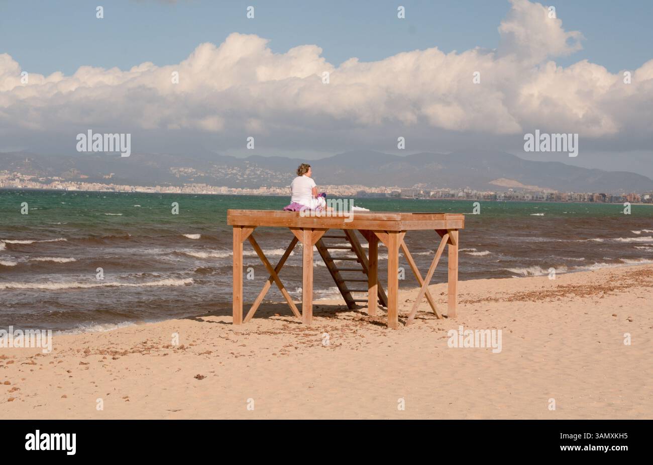 Tourist sat on a wooden lifeguard platform on the beach in Les ...