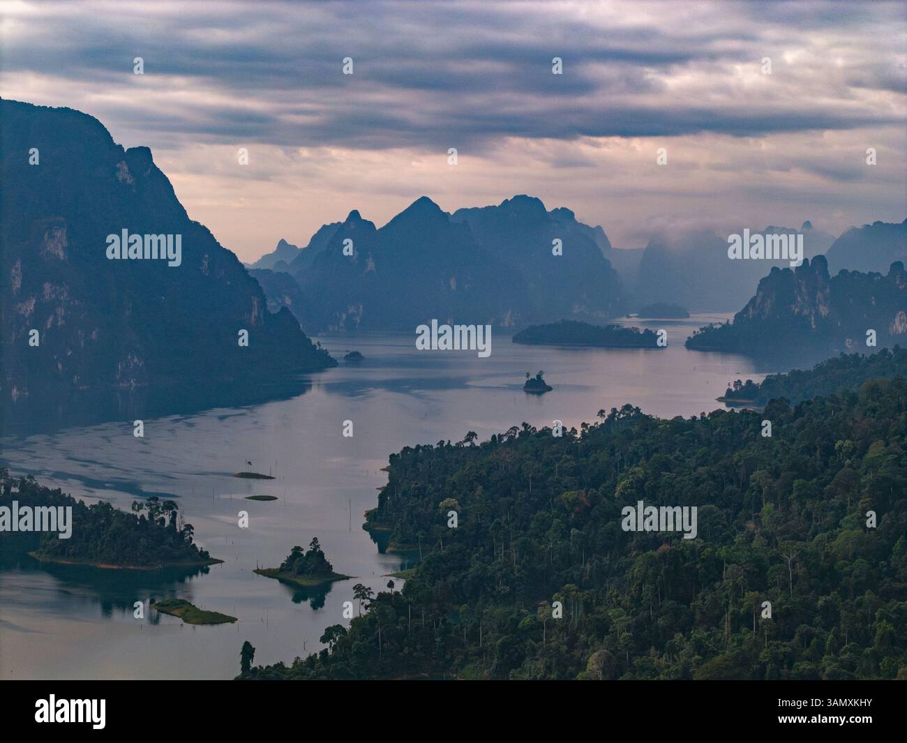 Aerial view of Cheow Larn Lake at sunrise surrounded by lush rainforest ...