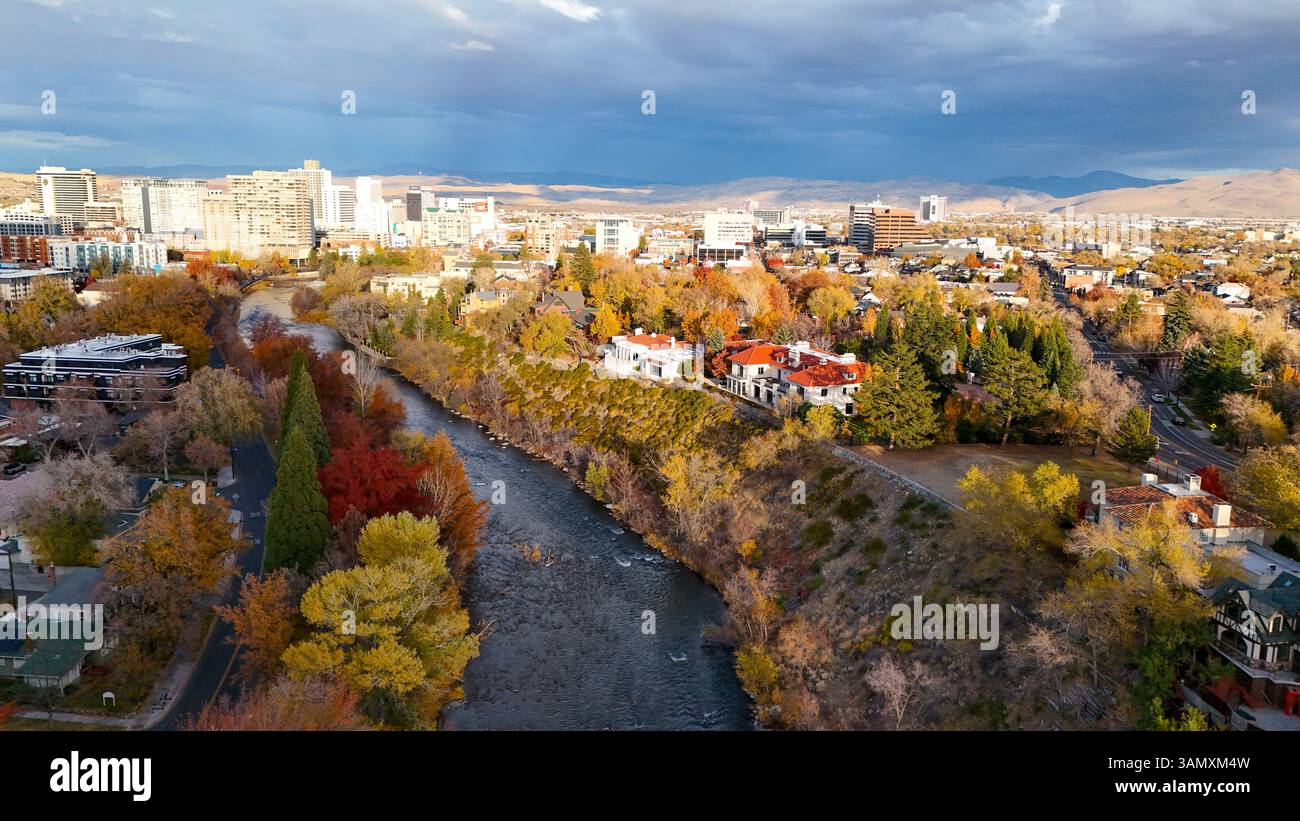 Aerial view of vibrant fall leaves and serene river amidst urban ...