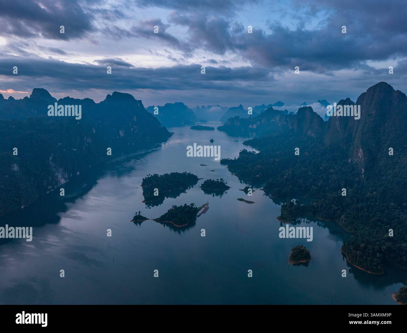 Aerial view of Cheow Larn Lake at sunrise surrounded by lush rainforest ...