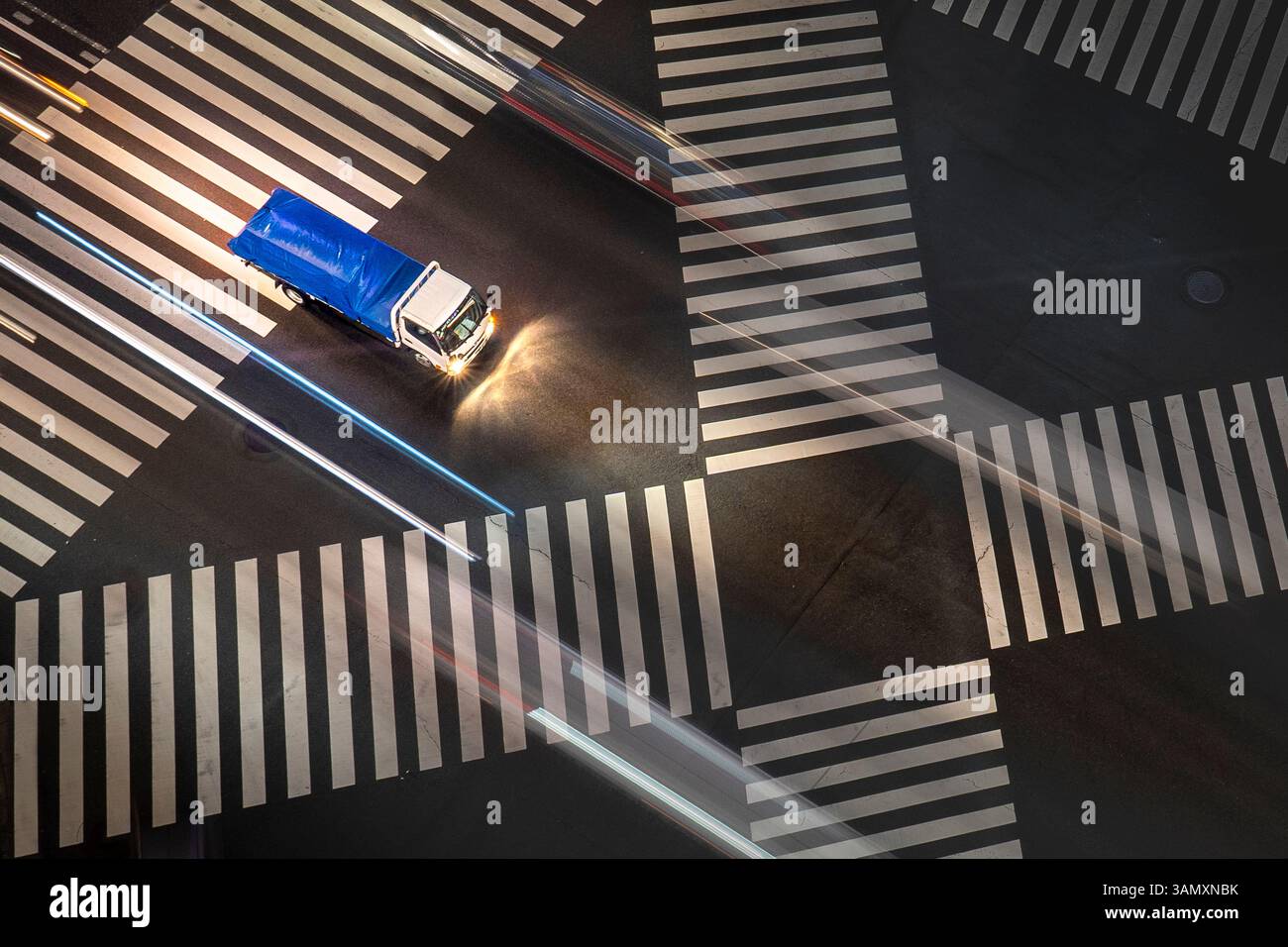 Aerial view of a bustling traffic junction with light streaks and zebra ...